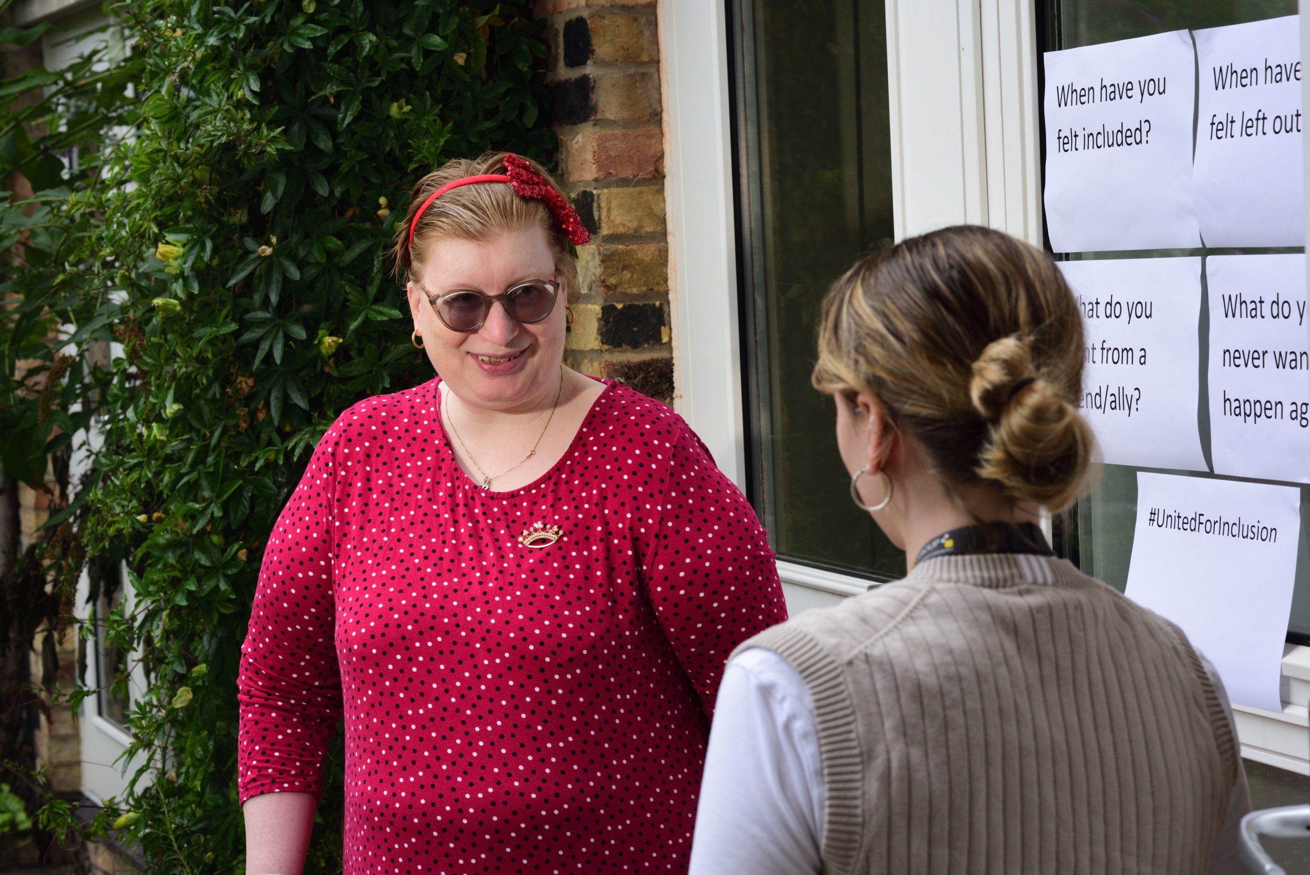 Smiling female resident talking to female support worker in front of ...